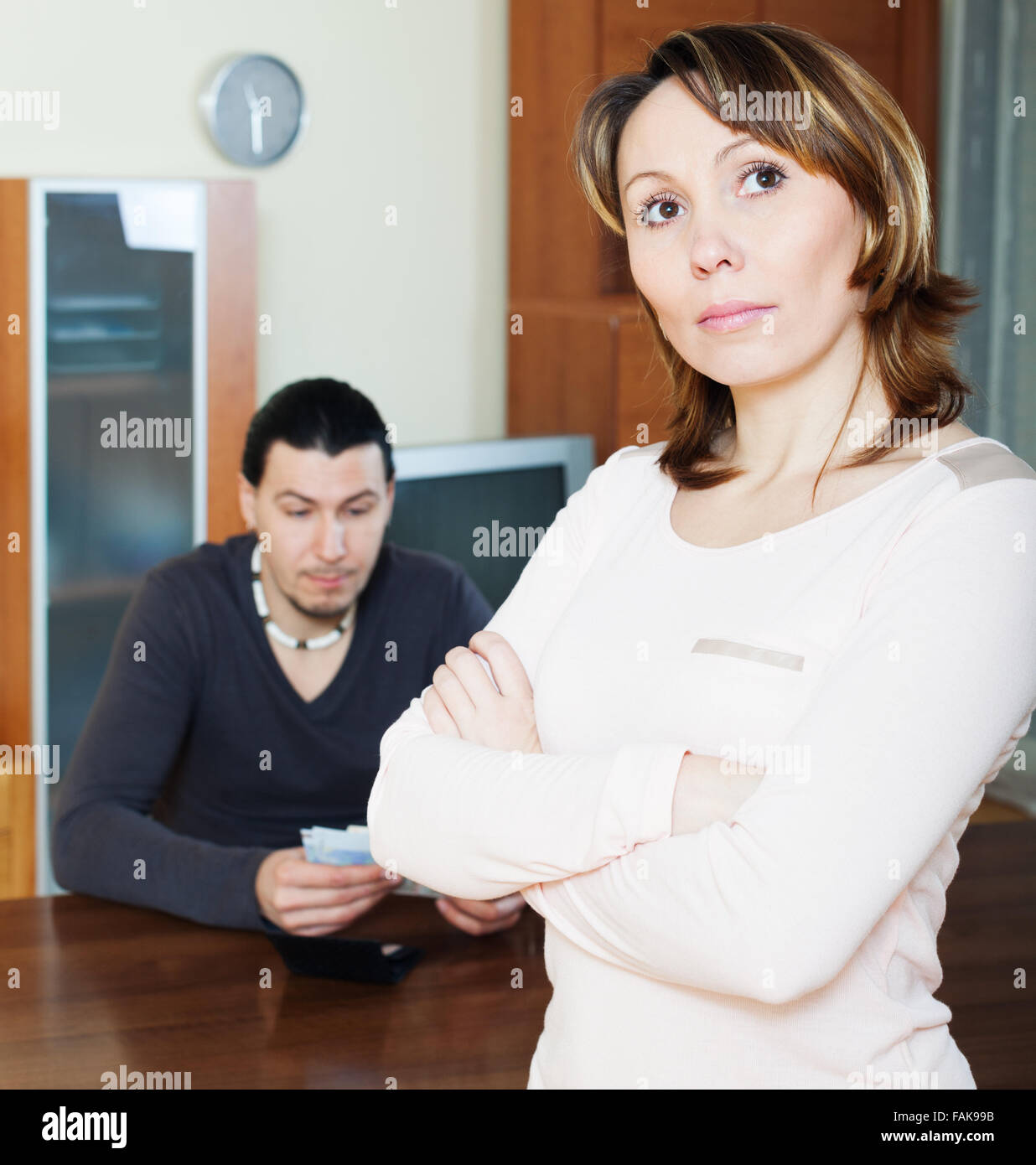 Financial problems in family. Sad woman against man with money Stock ...
