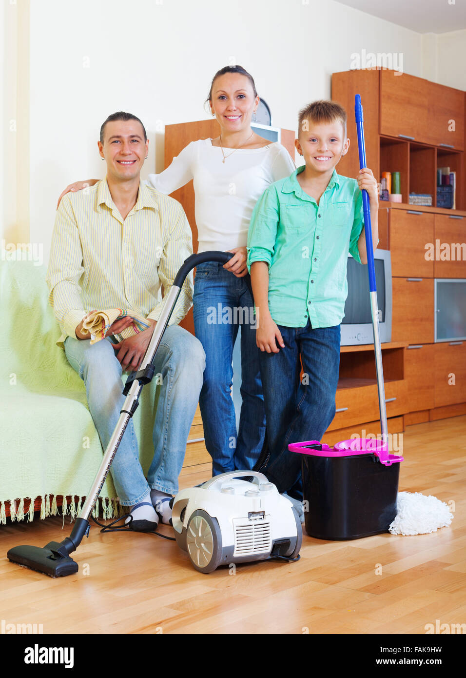 Portrait of happy family of three finished housework in home Stock ...