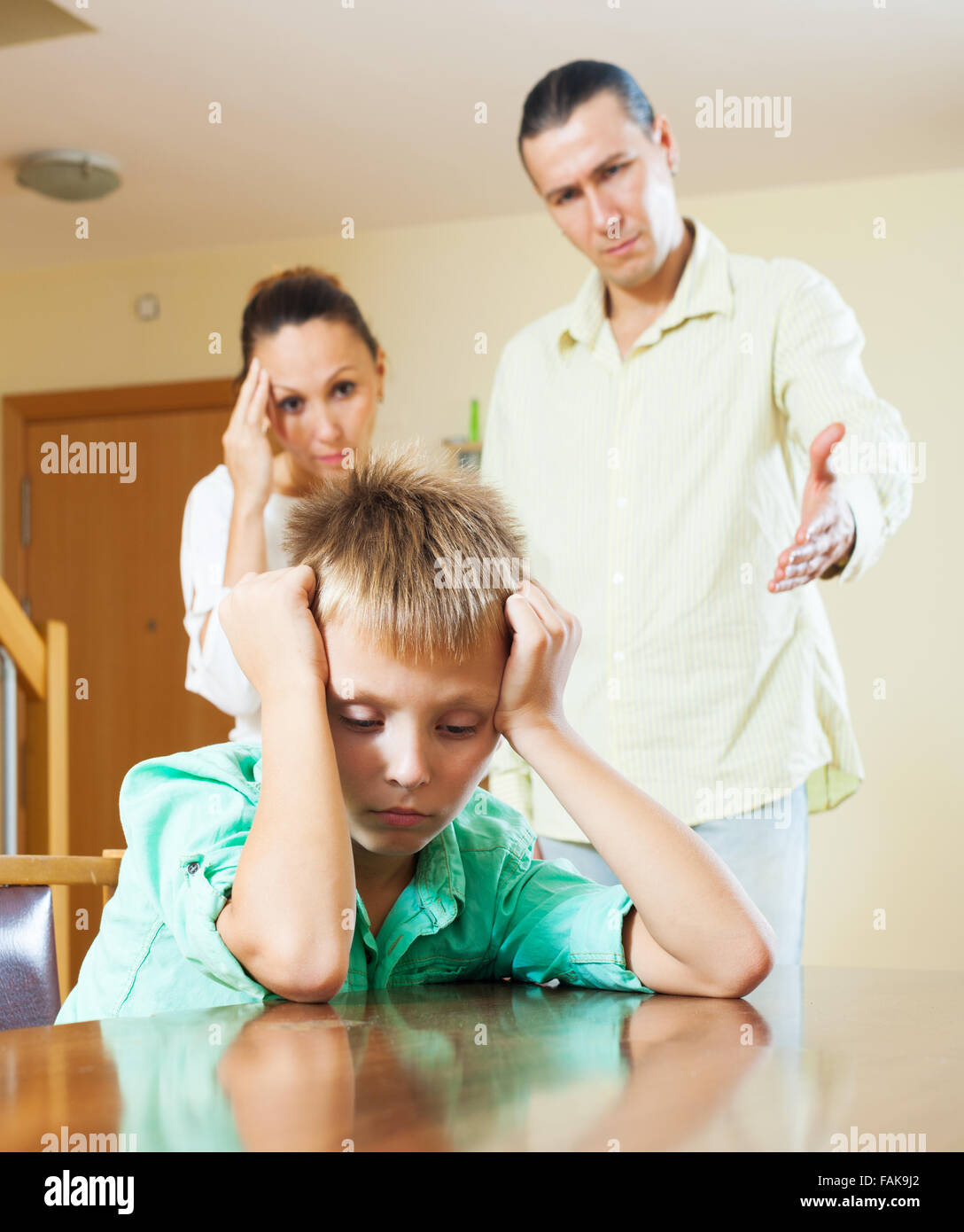 Ordinary family of three with teenage son having conflict. Focus on boy ...