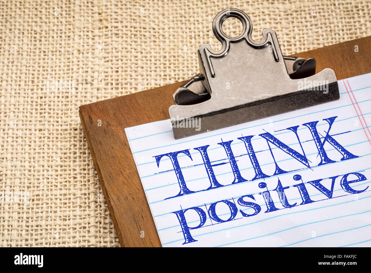 think positive concept - text in handwriting font on a clipboard ...