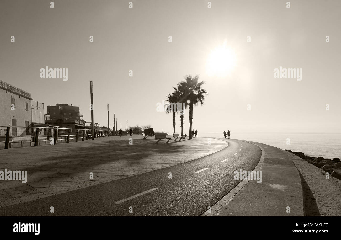 Sunny route with silhouette people biking along the Mediterranean in ...