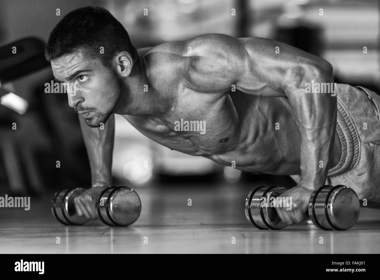 Young Athlete Doing Pushups With Dumbbells As Part Of Bodybuilding ...