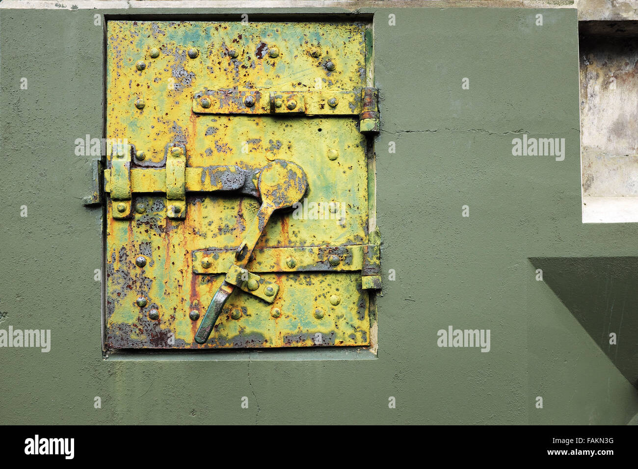 Rusty yellow steel door on wall of green concrete bunker, Artillery ...