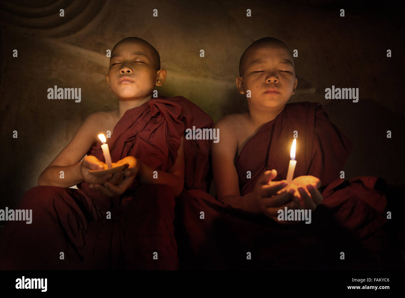 Little monks praying with candlelight Stock Photo - Alamy