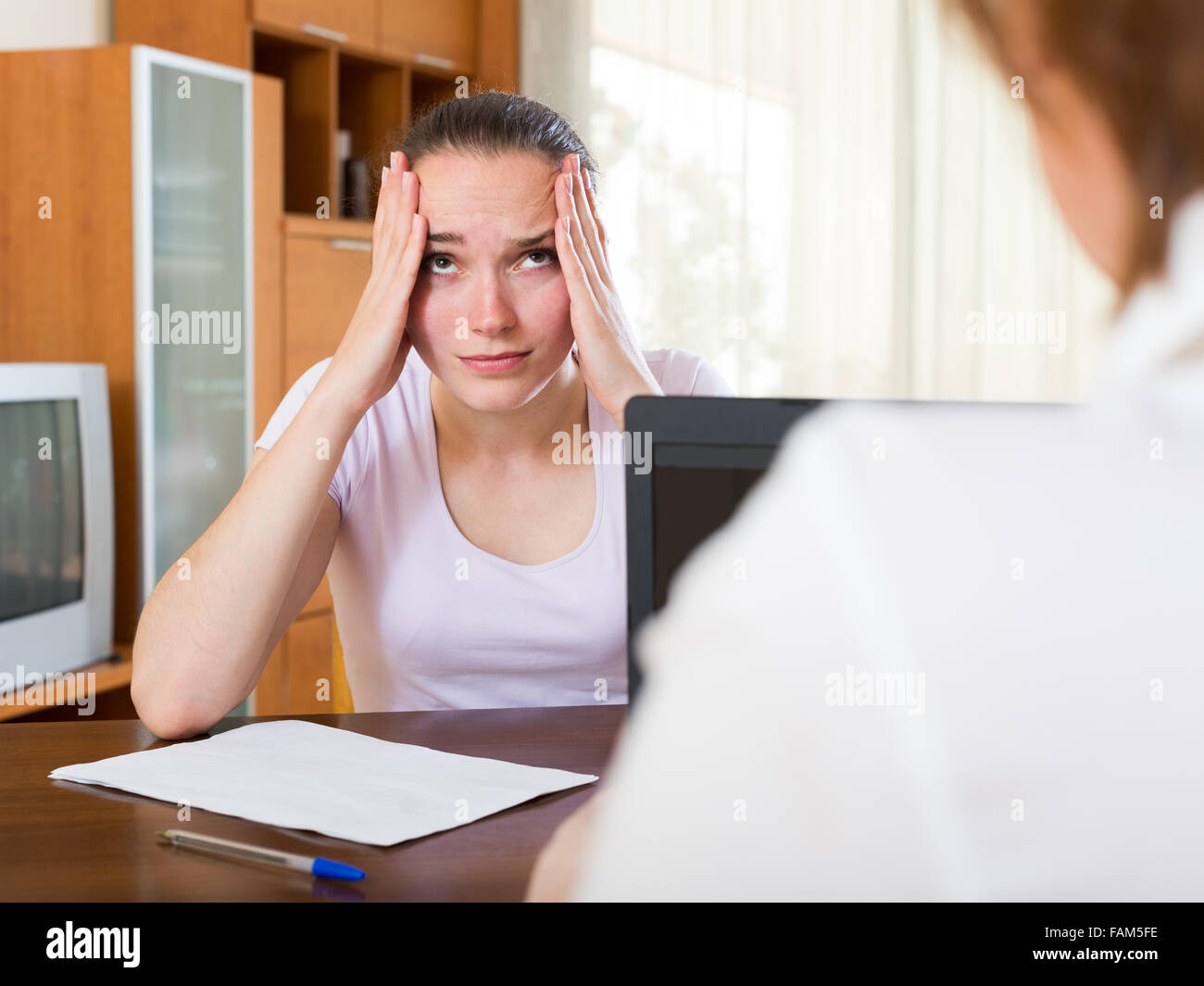 Sad woman answer questions of worker at table in office Stock Photo - Alamy