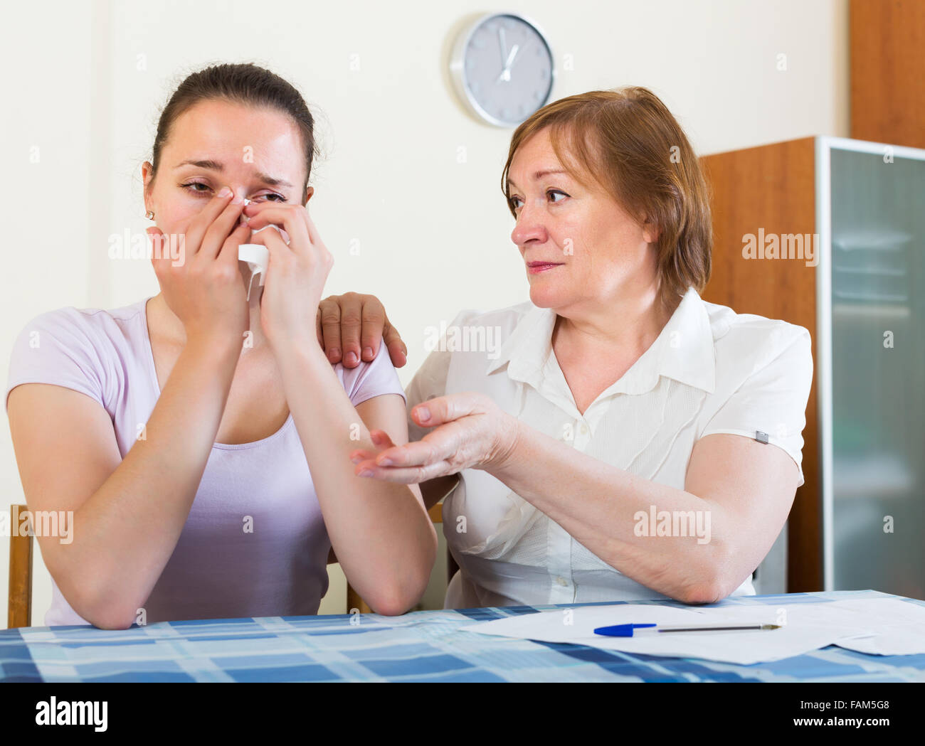 Serious cry women reading documents at table in office Stock Photo - Alamy