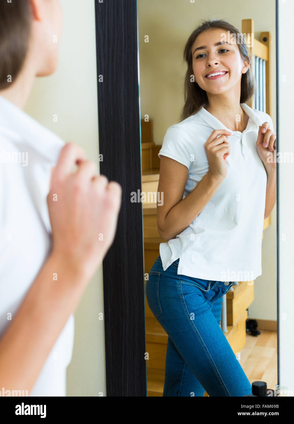 Happy young girl looking at her reflection in the mirror Stock Photo ...