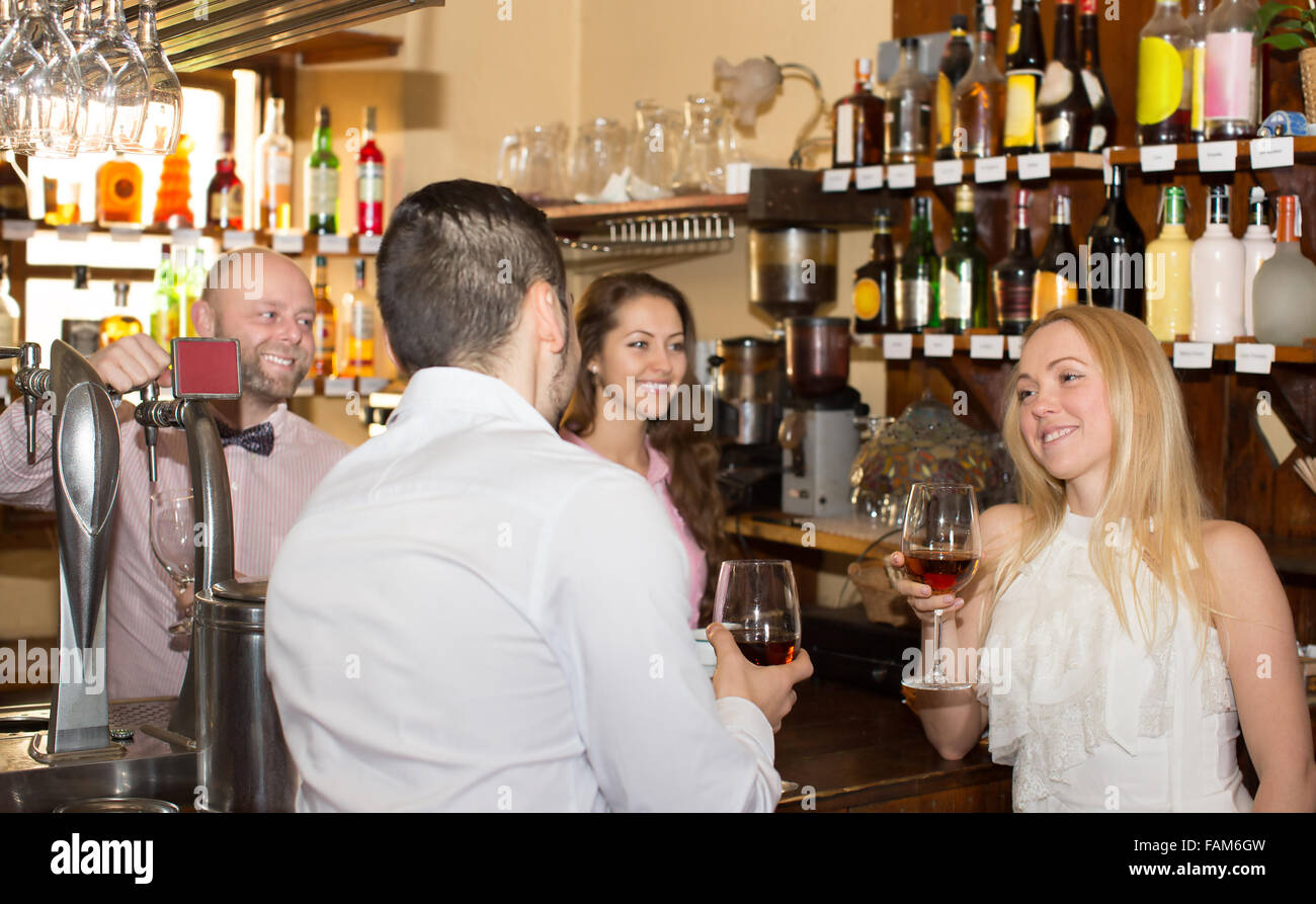 Happy bartender entertaining guests at bar counter Stock Photo - Alamy