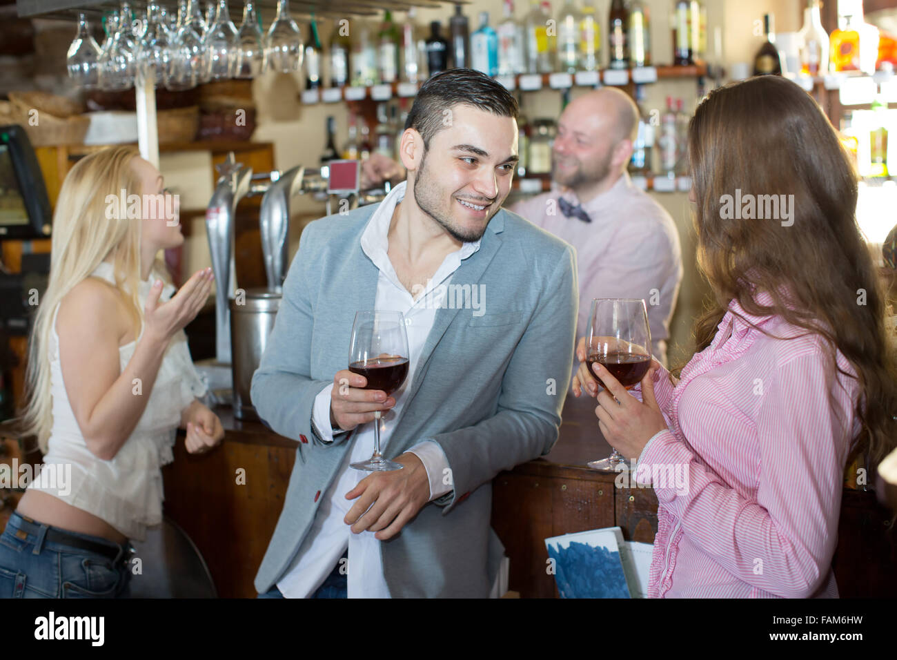 Positive bartender entertaining guests at the bar counter in bar Stock ...