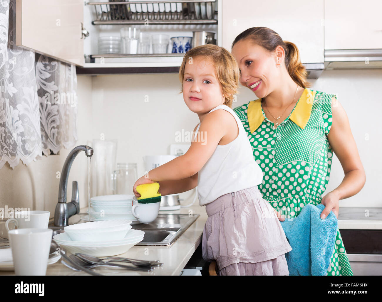 Daughter with mother washing dishes in kitchen Stock Photo - Alamy