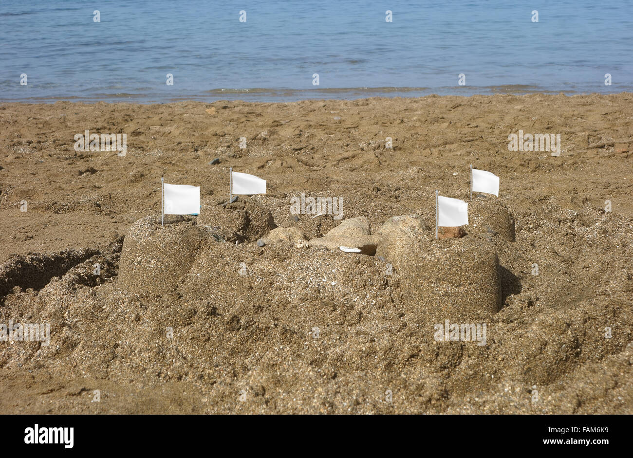 Sand castle with white flags , capitulation concept Stock Photo - Alamy