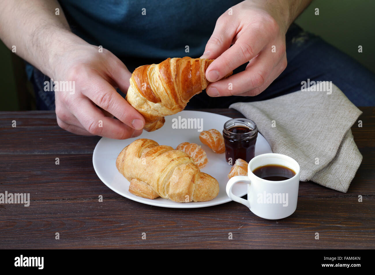 man eating a croissant with jam for breakfast Stock Photo - Alamy