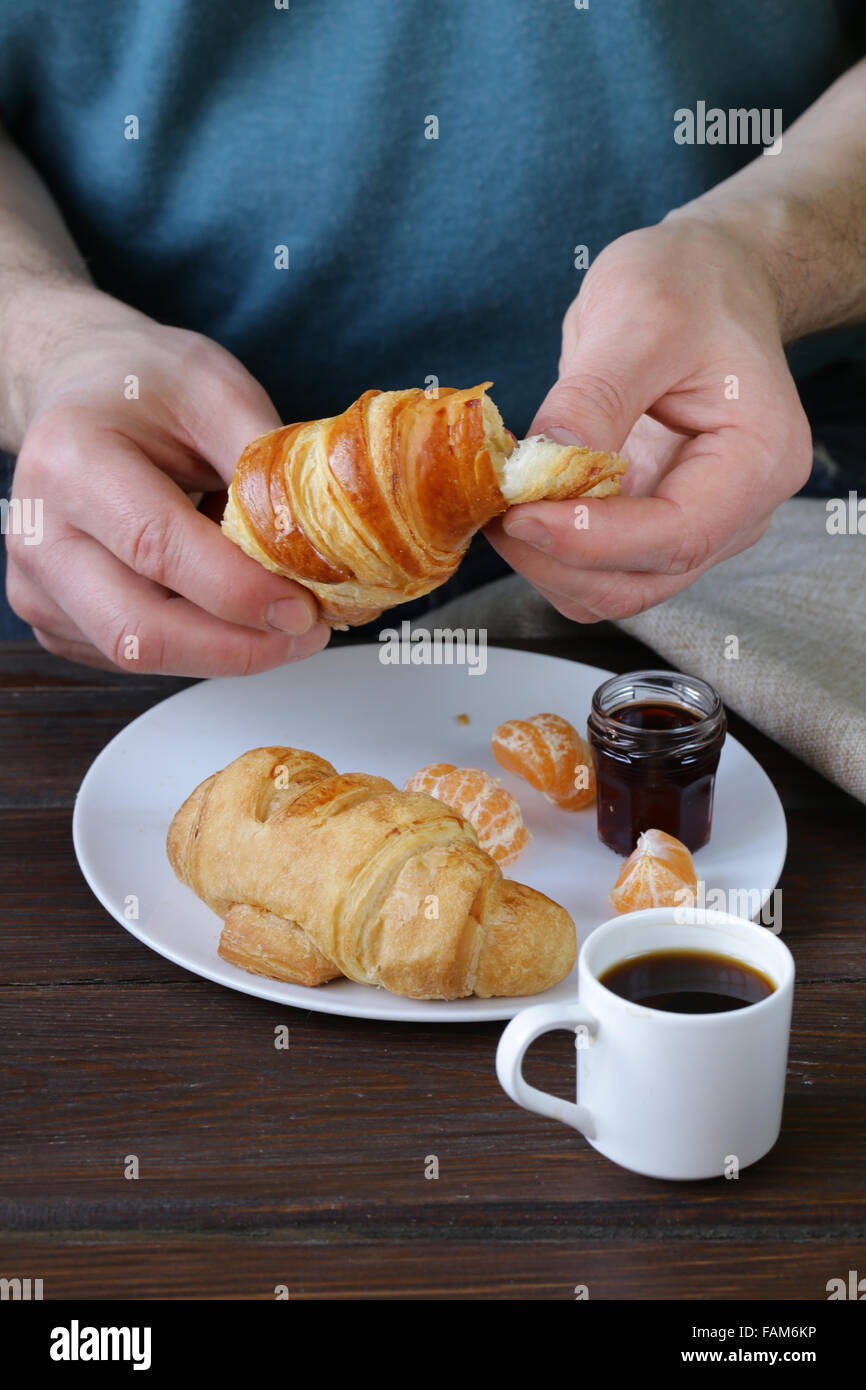 man eating a croissant with jam for breakfast Stock Photo - Alamy