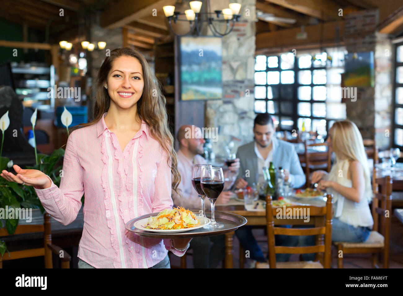 Portrait of happy adults having dinner and respectful waiter Stock ...