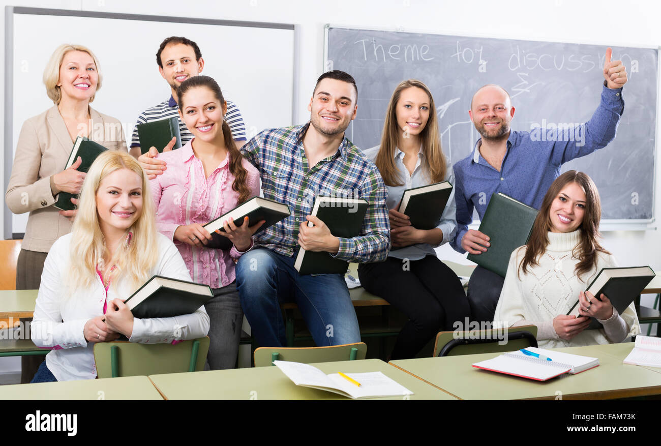 Portrait of friendly teacher and happy students in classroom Stock ...