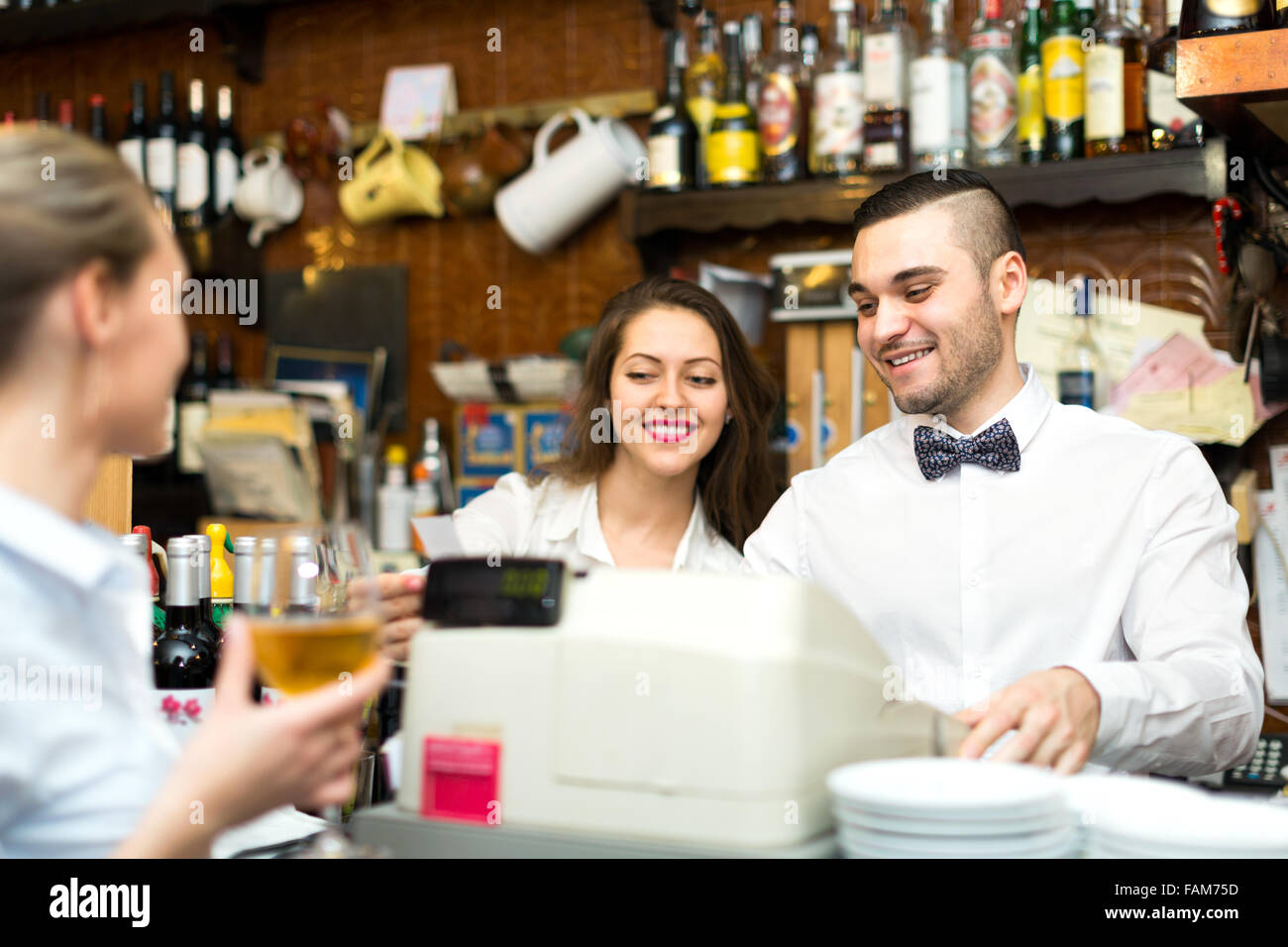 Friendly personnel working in a bar. A beautiful young waitress with a ...
