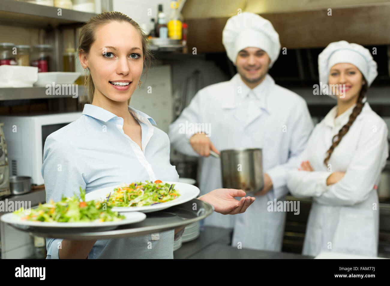 Beautiful female waiter taking dish from kitchen Stock Photo - Alamy