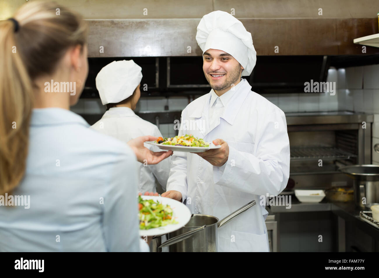 Team of chefs and waitress at the work at restaurant kitchen Stock ...