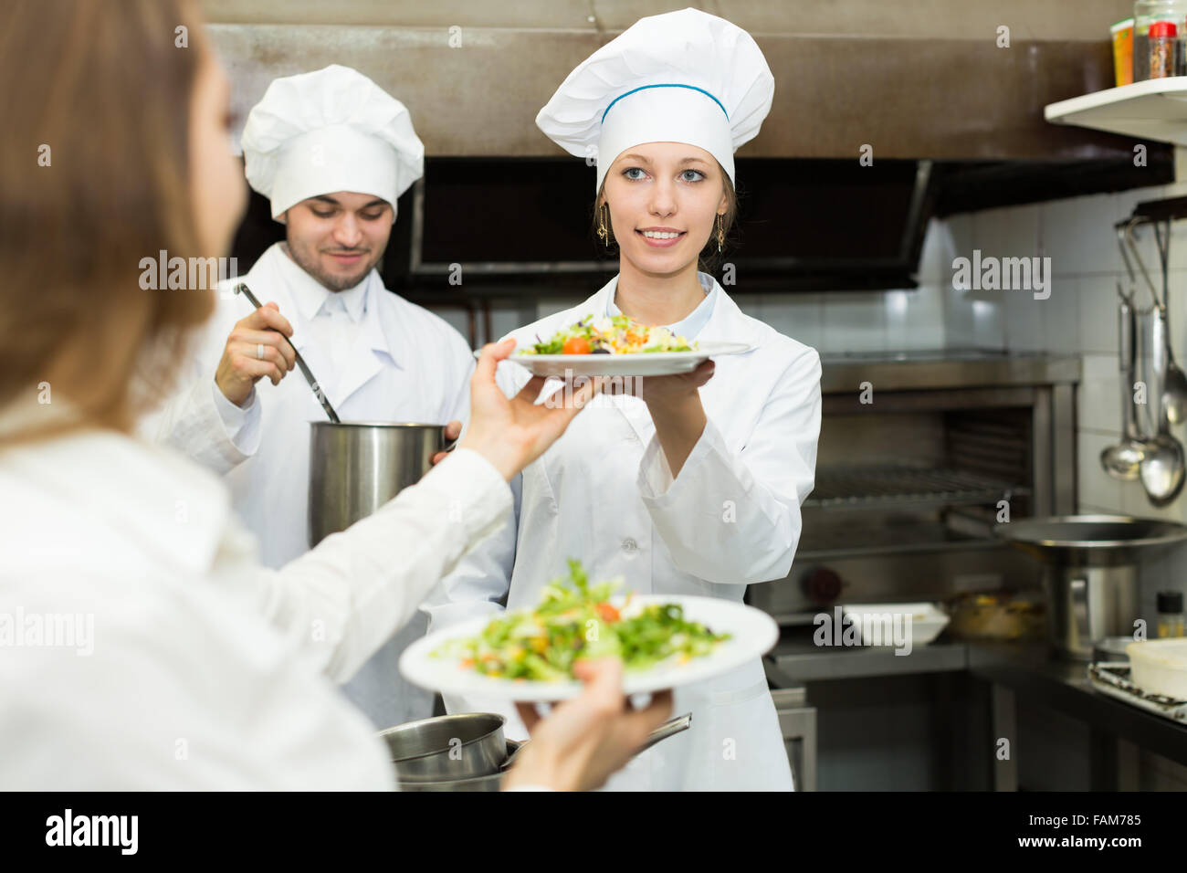 Team of happy chefs and young waiter at the restaurant kitchen Stock ...