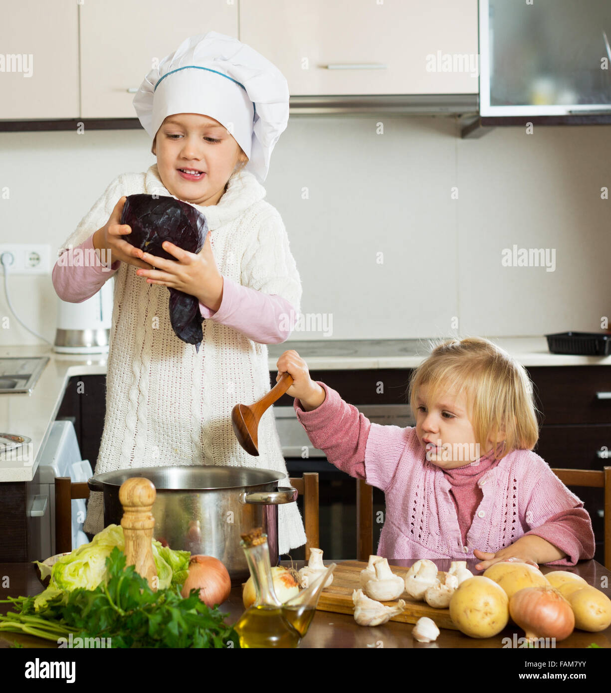 Mama's daughter learning to cook soup on kitchen table Stock Photo - Alamy