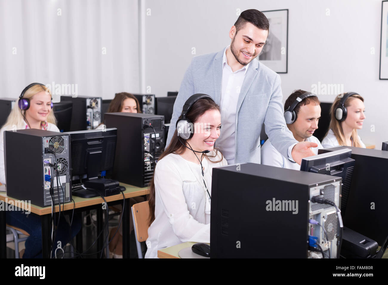 Smiling male supervisor and employees of technical support line working ...