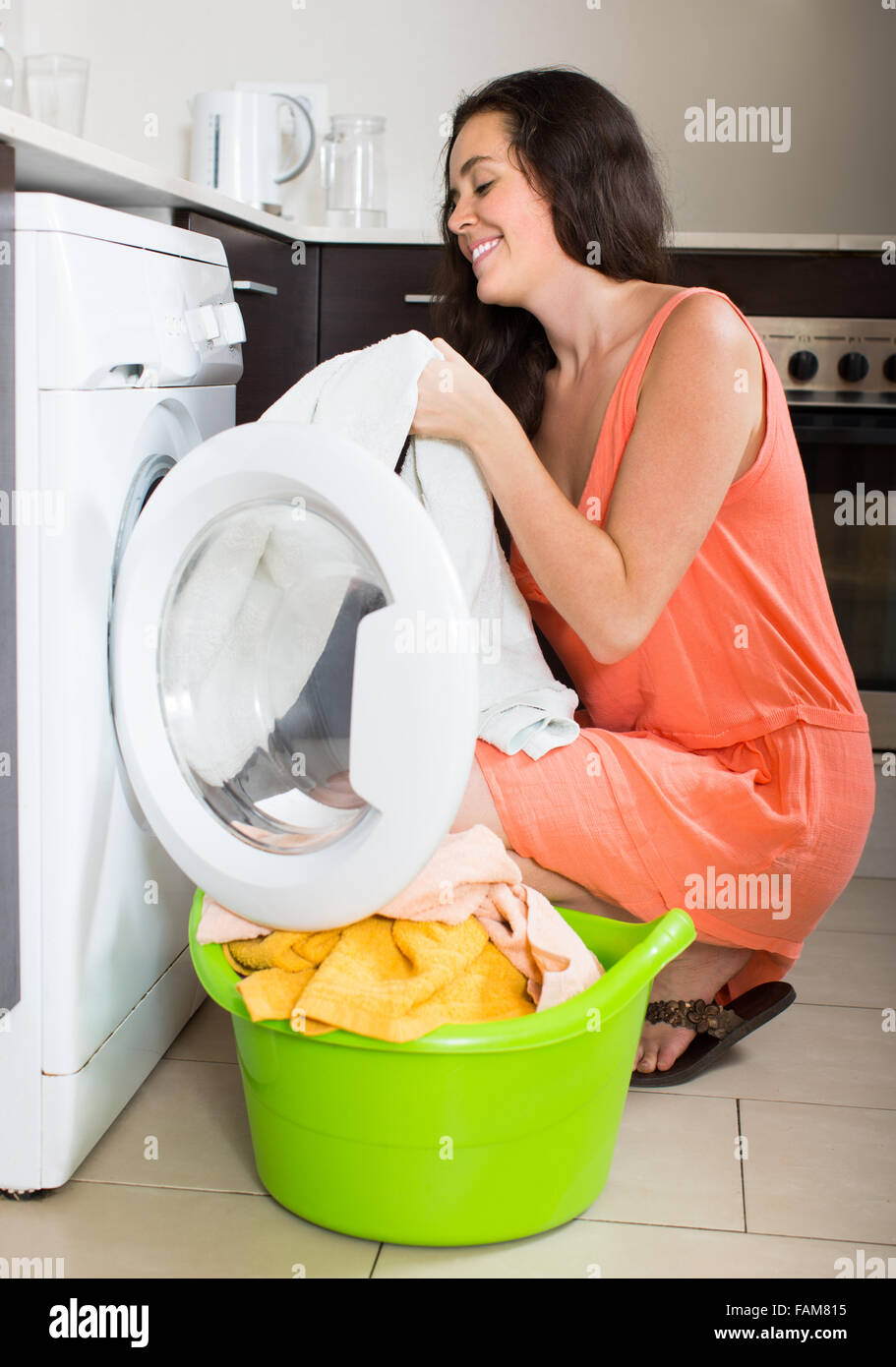 Home laundry. Smiling woman using washing machine at home Stock Photo ...