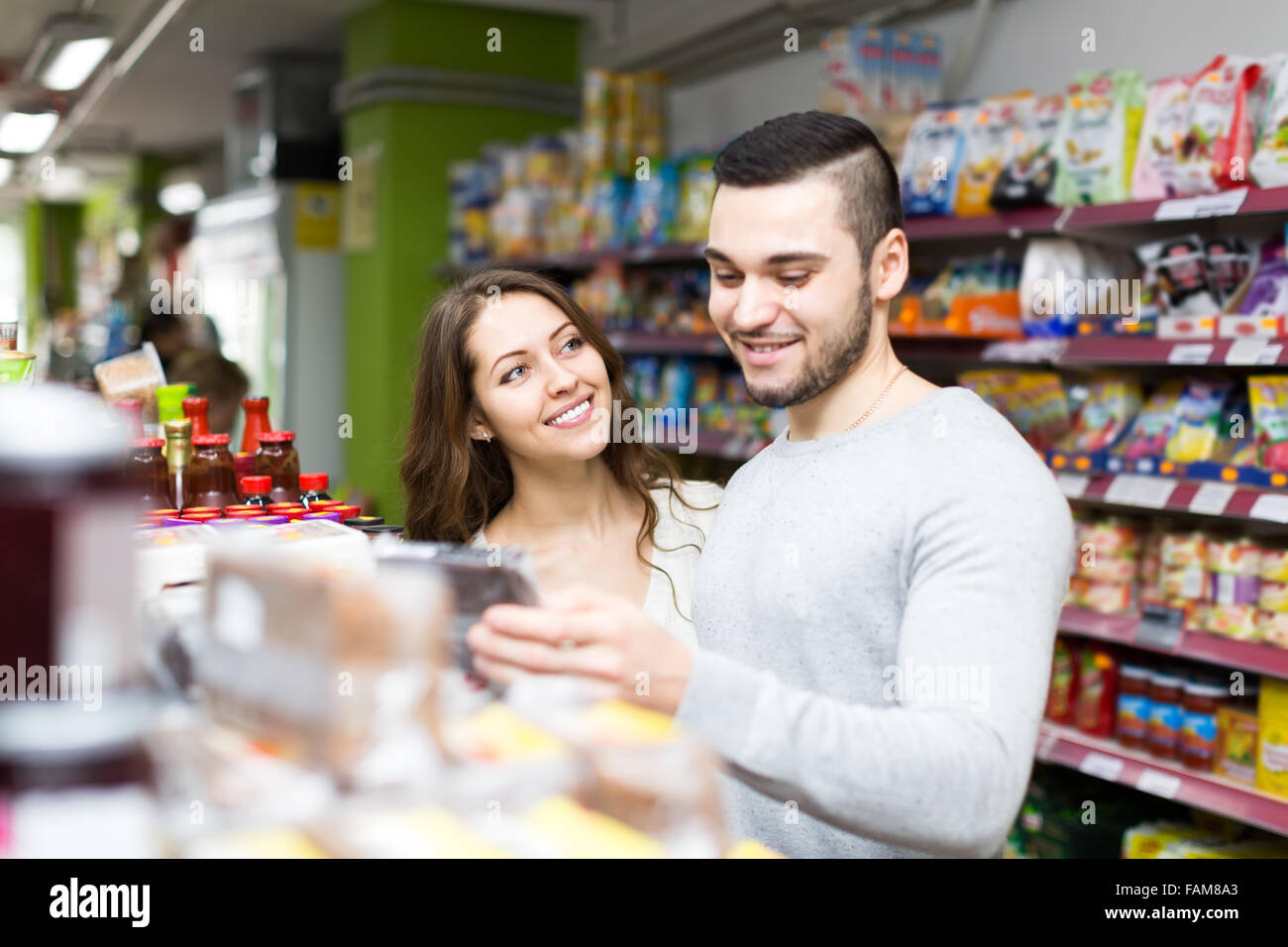 Smiling happy woman shopping for food in a supermarket with her beloved ...