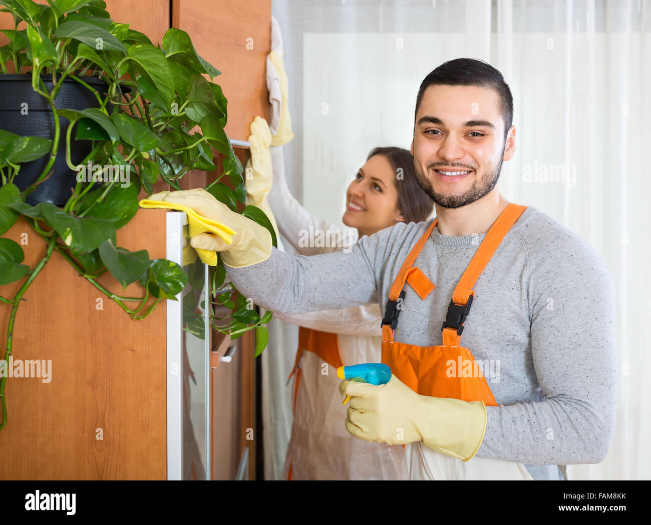 Positive professional cleaners with equipment working at client house ...