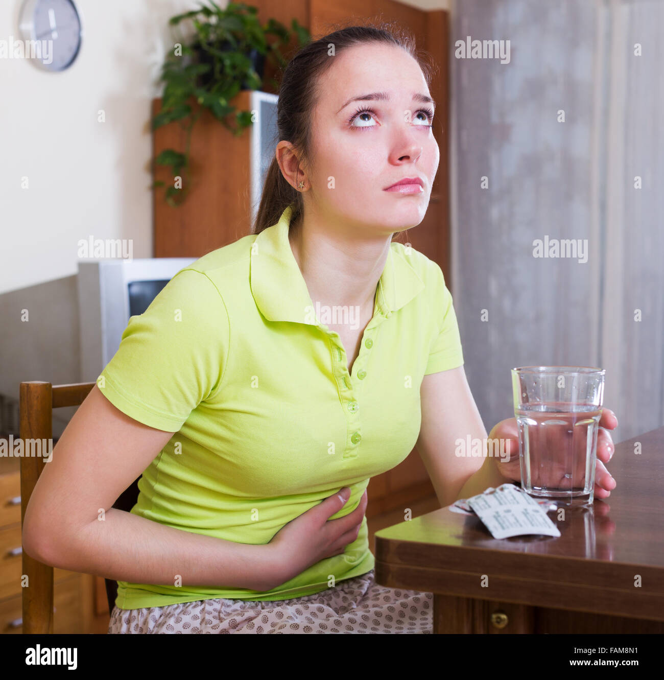 Portrait of unhappy woman having stomach aches at home Stock Photo - Alamy