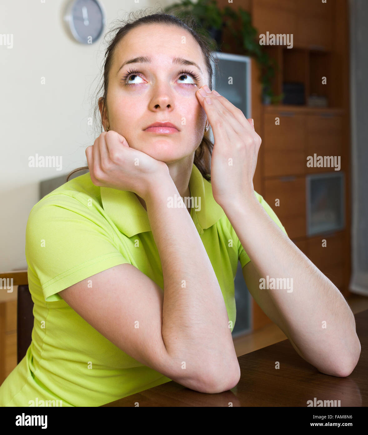 Sad young woman sitting alone at home and crying Stock Photo - Alamy