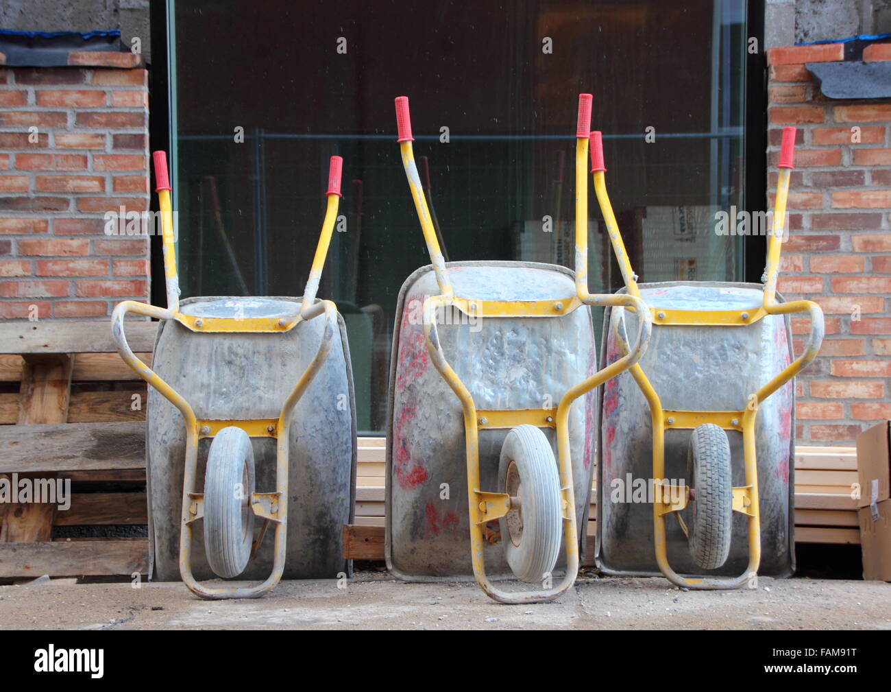 Three Metal Wheelbarrows with Red Handles at Construction Site Closeup ...