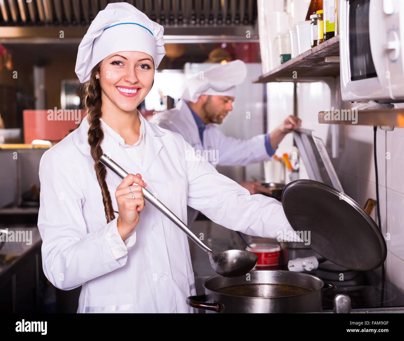 Happy smiling cooks working at take-away restaurant kitchen Stock Photo ...