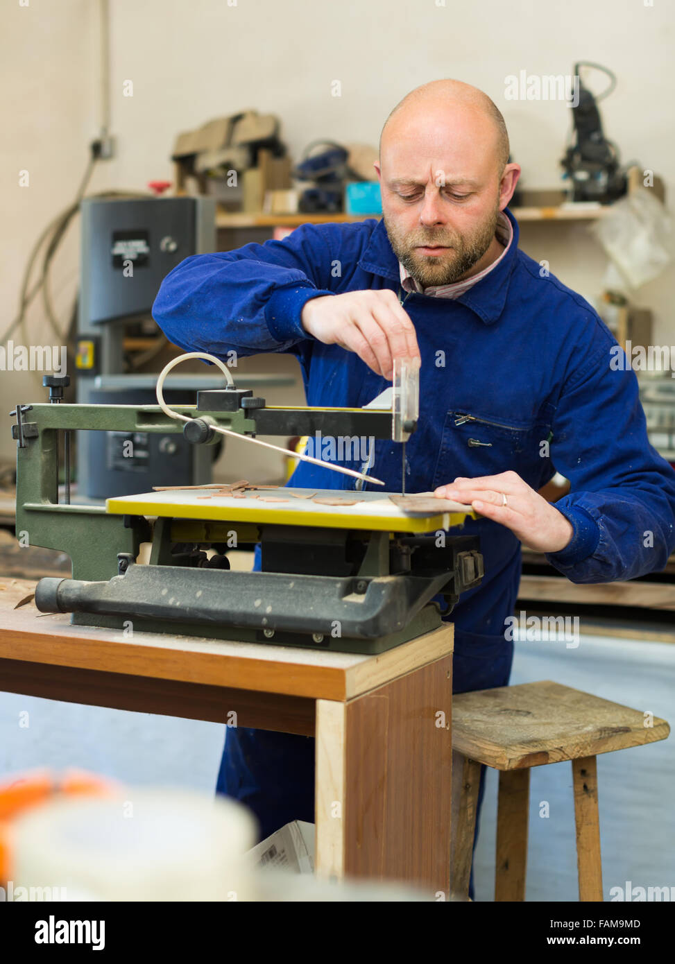 Serious woodworker working on a machine at wood workshop Stock Photo ...