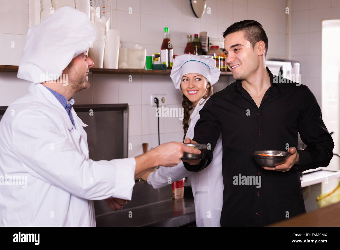 Happy chefs and handsome waiter working at eating house Stock Photo - Alamy