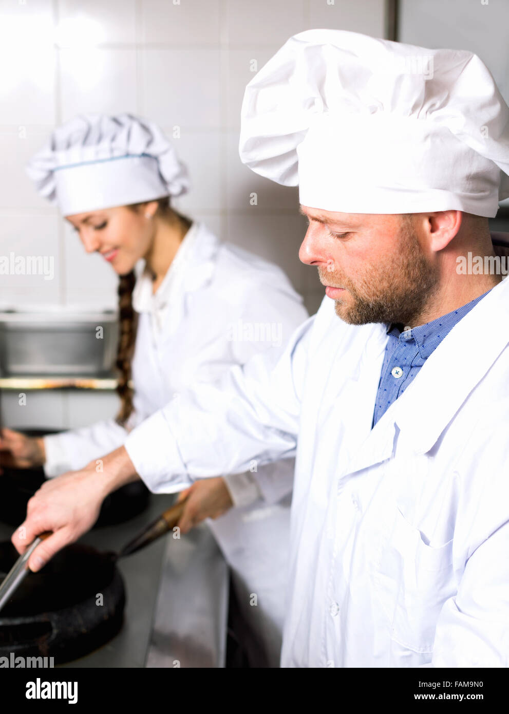 Chef and cook working at take-away restaurant kitchen Stock Photo - Alamy