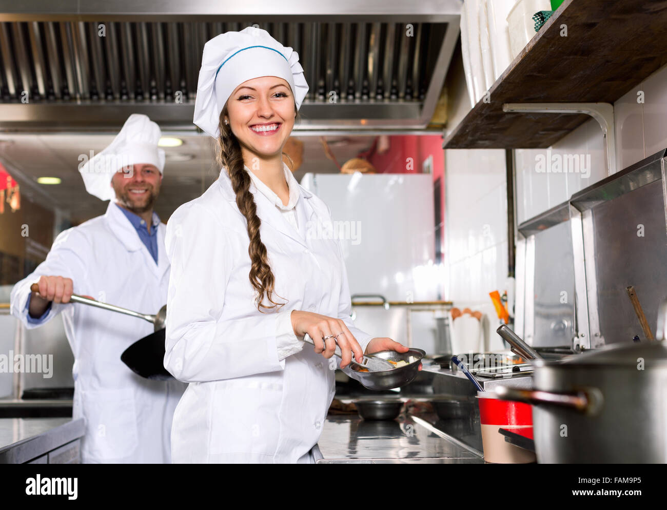 Professional chef and cook working at take-away restaurant kitchen ...