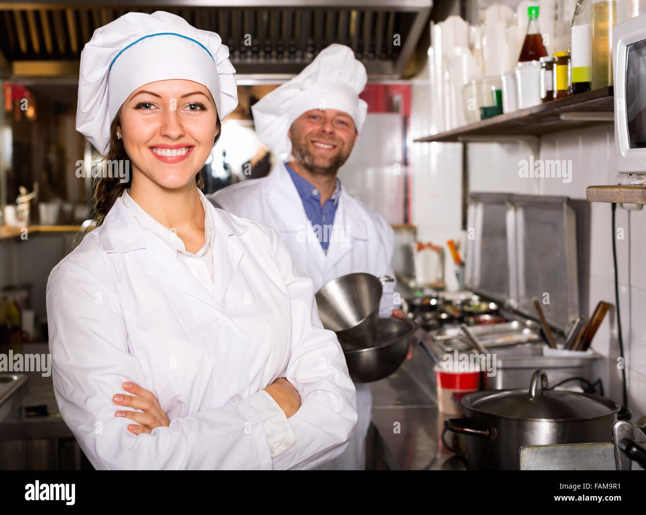 Happy chef and cook working in restaurant kitchen Stock Photo - Alamy
