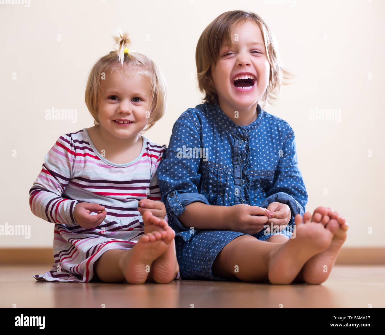 happy little girls sitting on the floor Stock Photo - Alamy