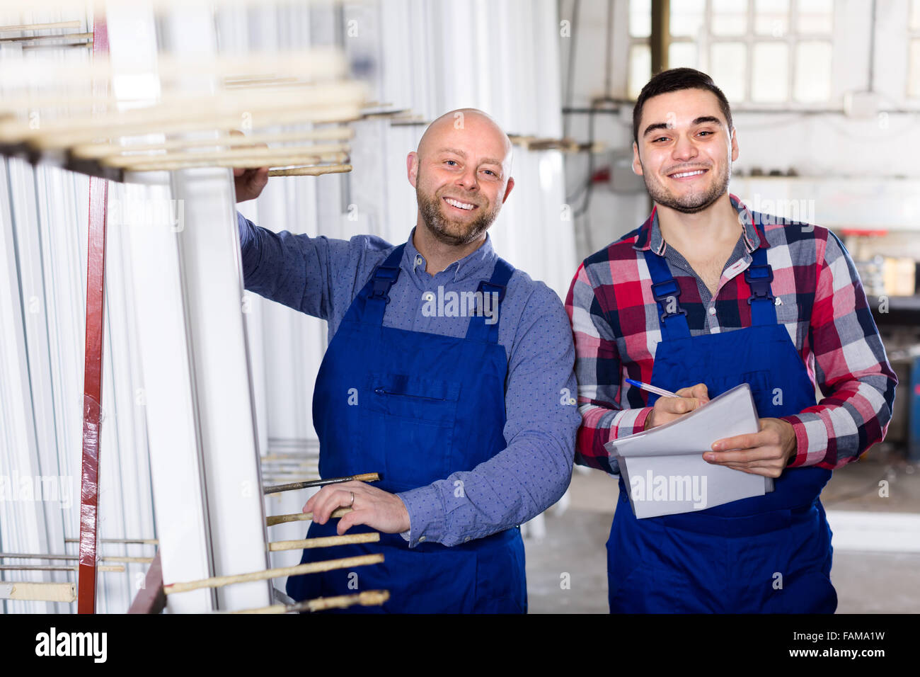 Smiling production workers in coverall with different PVC window in ...
