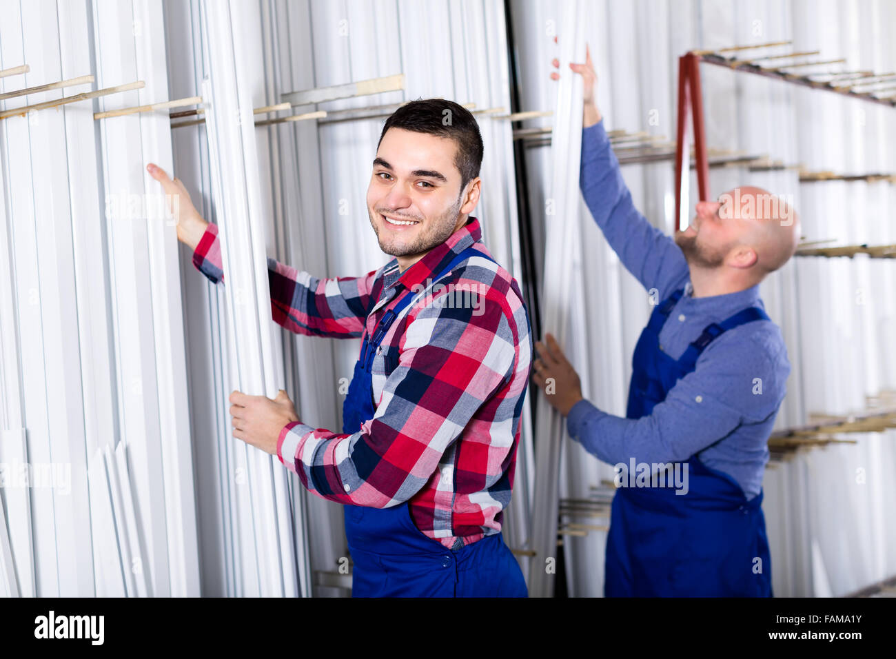 Workers at a window production factory selecting a specific PVC profile ...