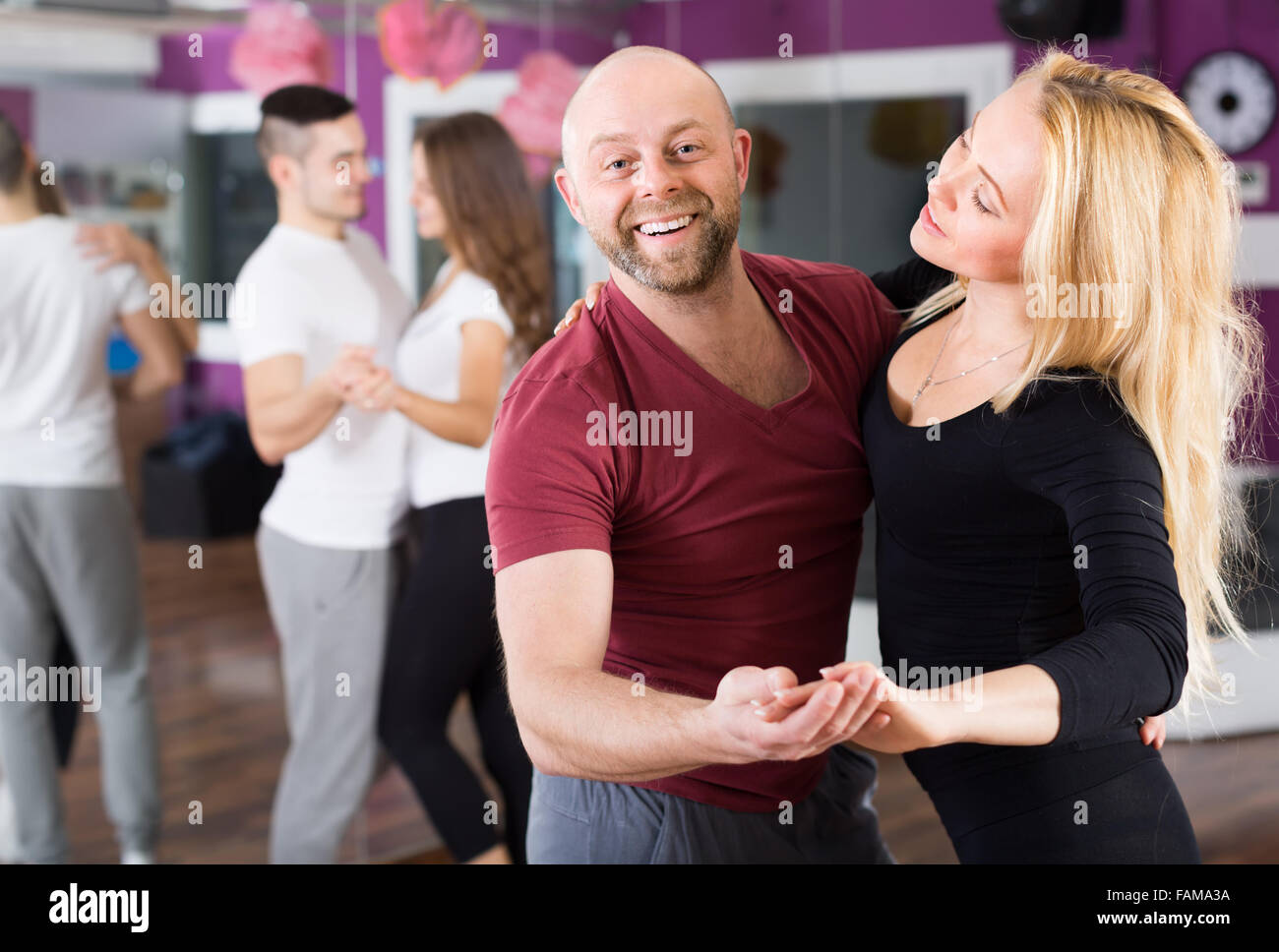 Two happy smiling young couples having dancing class in club Stock ...