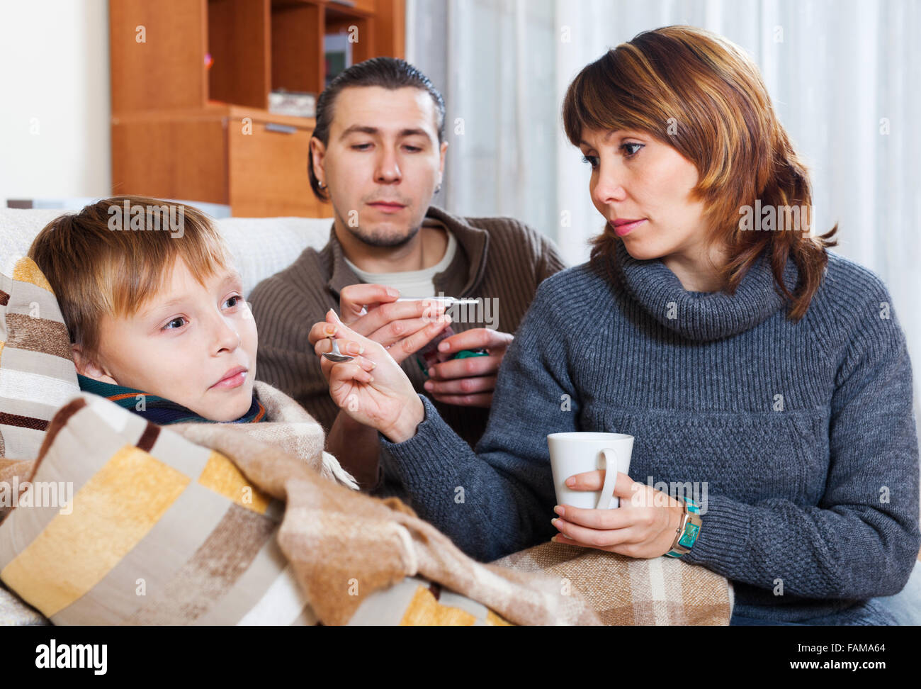 parents giving medicinal syrup to sick teen son Stock Photo - Alamy