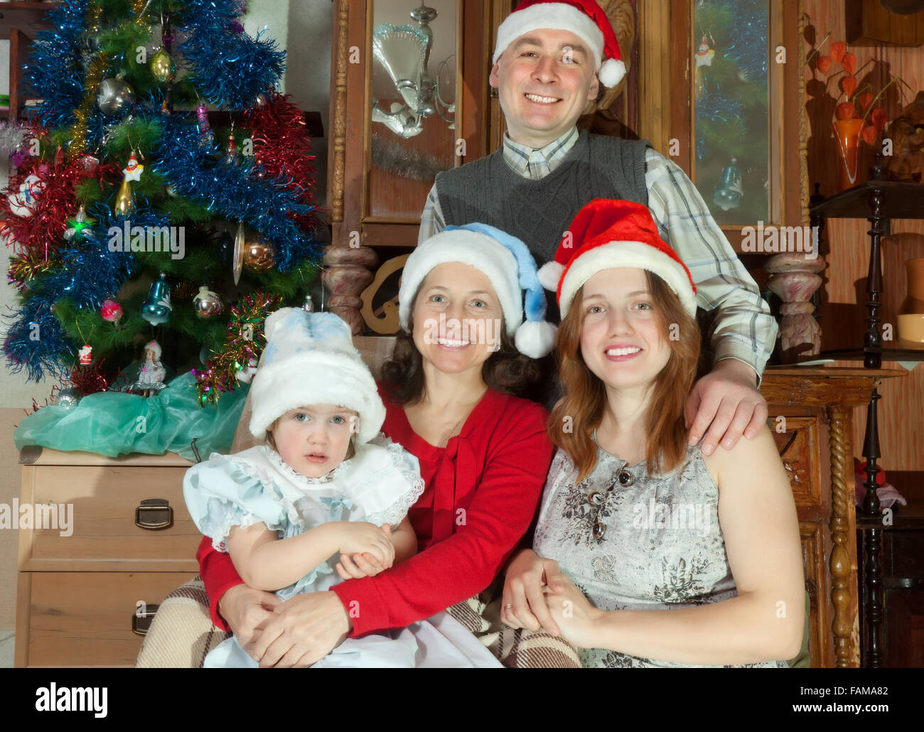 Happy family of three generations in santa hats celebrating Christmas ...