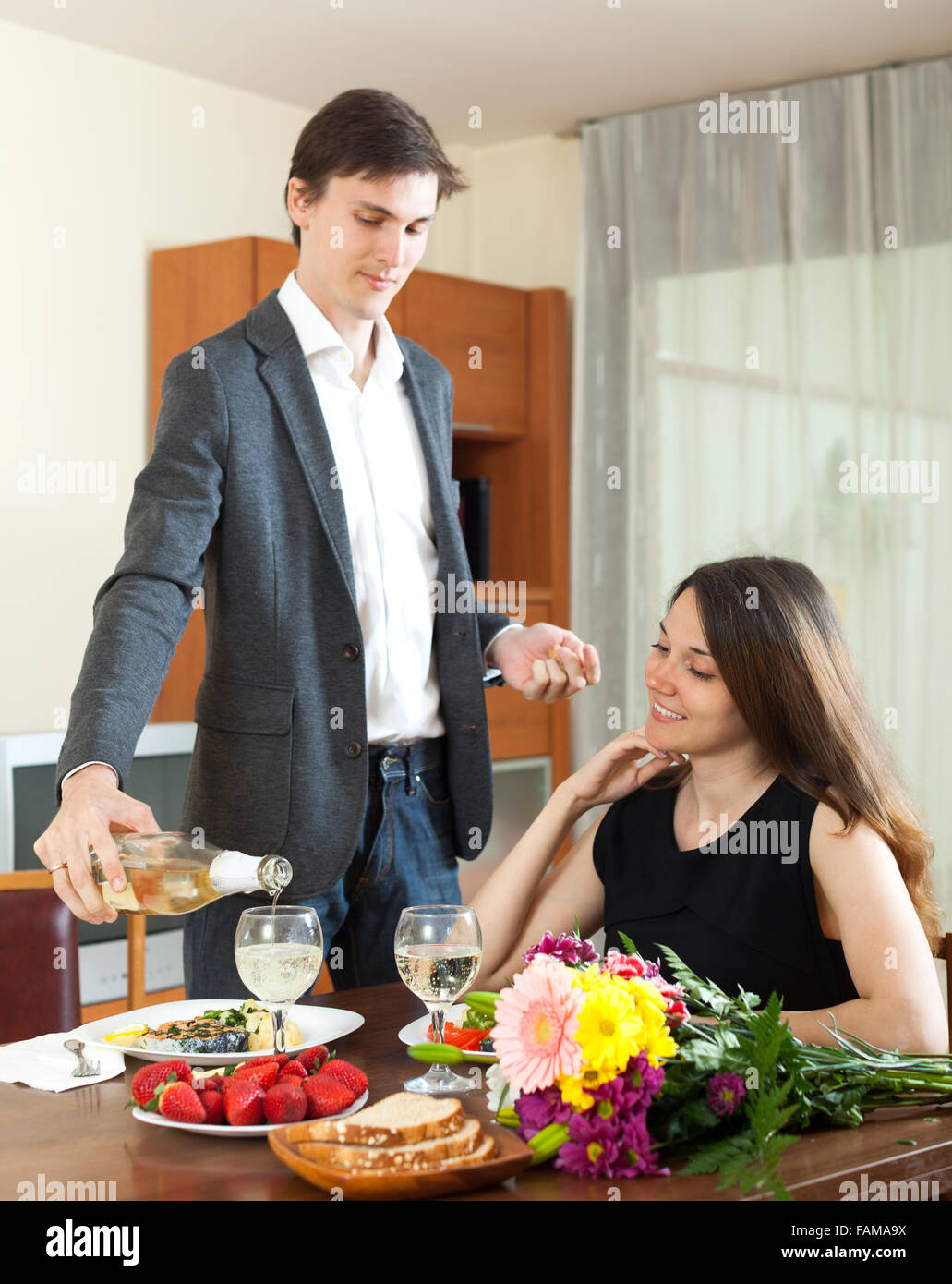 Young man and woman having romantic dinner in home Stock Photo - Alamy