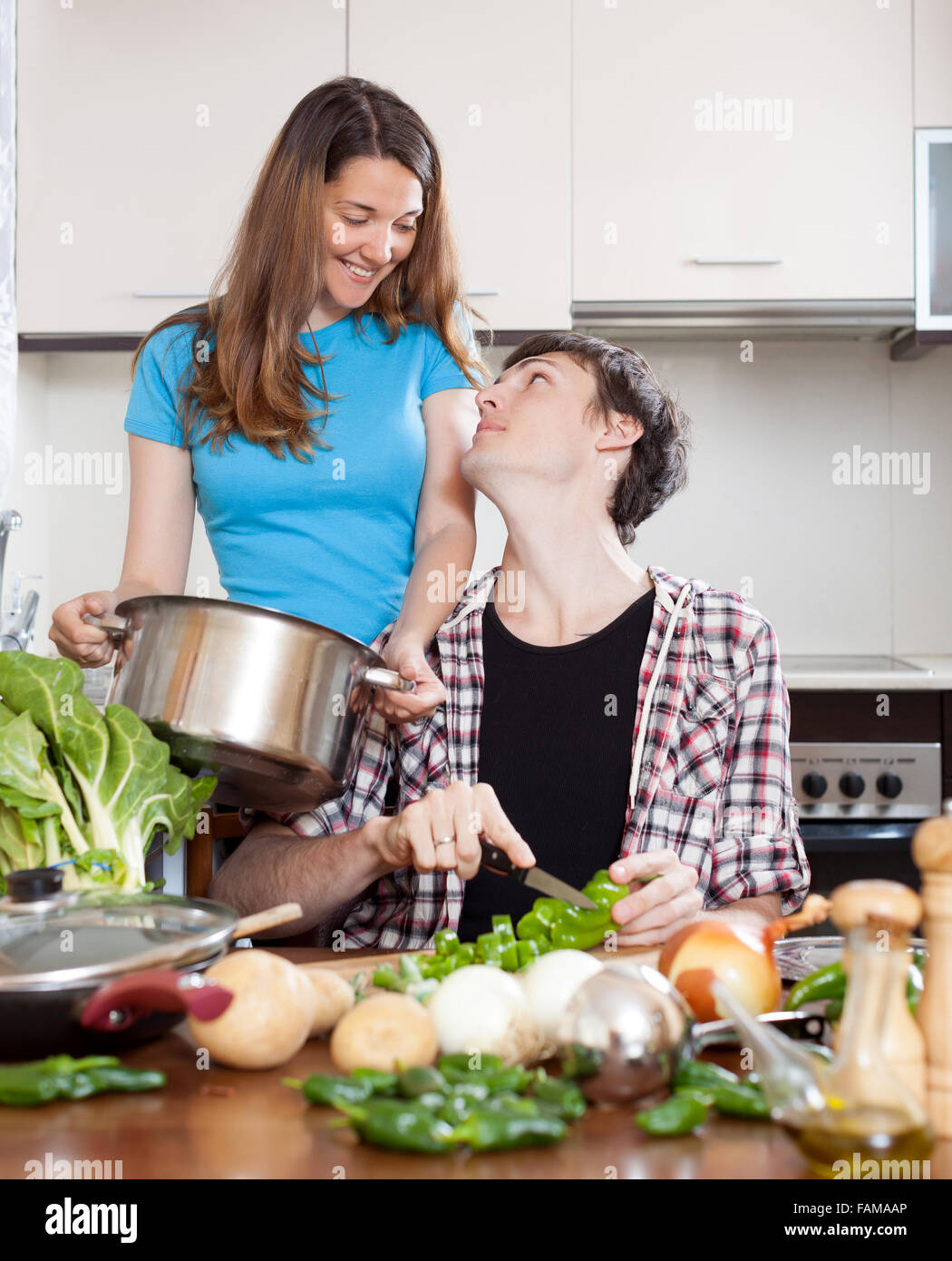 Loving guy and pretty girl cooking in domestic kitchen Stock Photo - Alamy