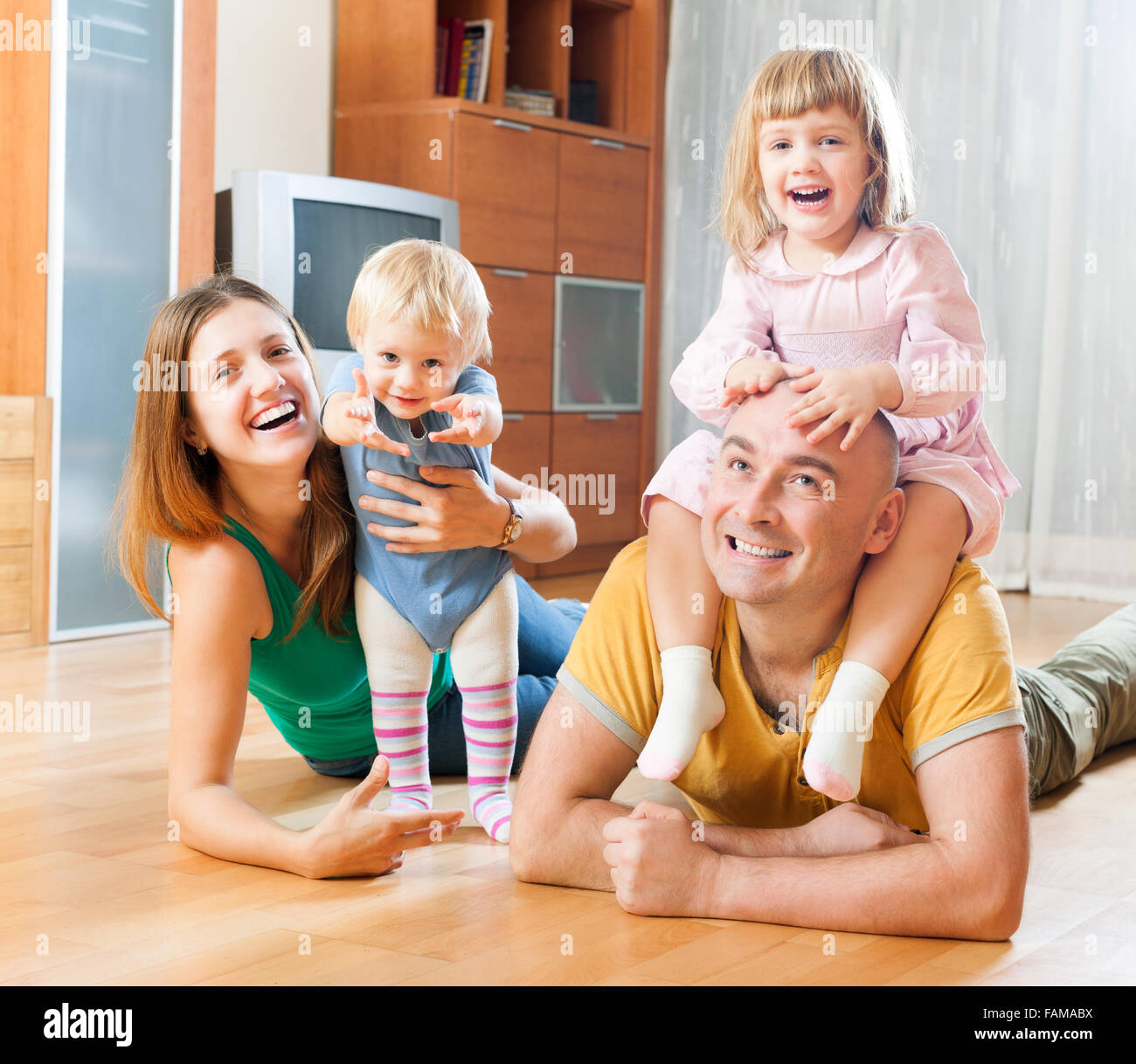 Joyful family with two children in home interior Stock Photo - Alamy