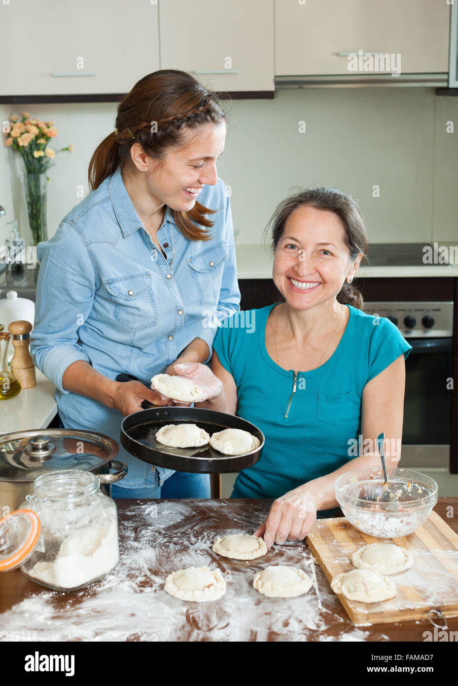 Two laughing women making pies together Stock Photo - Alamy