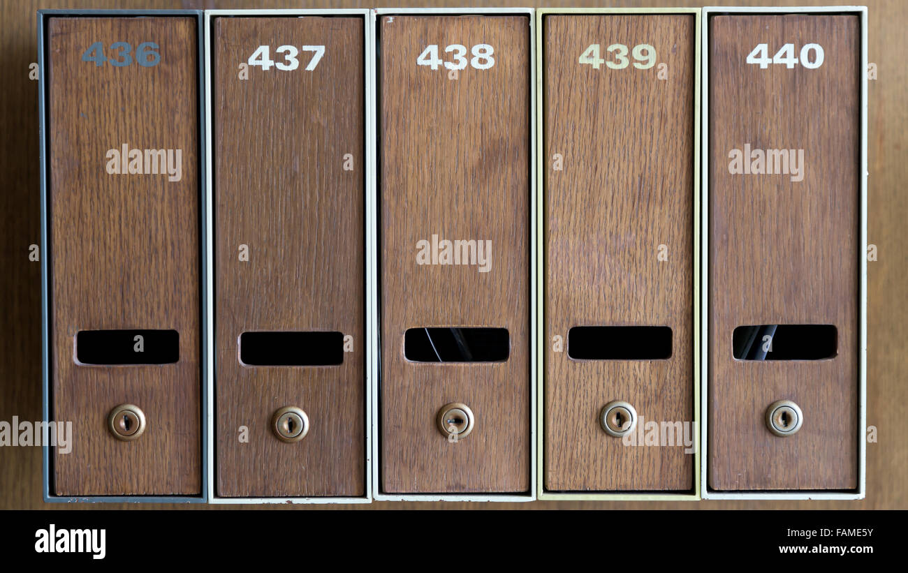 Five mailboxes with number are attached in the same group on the wall ...