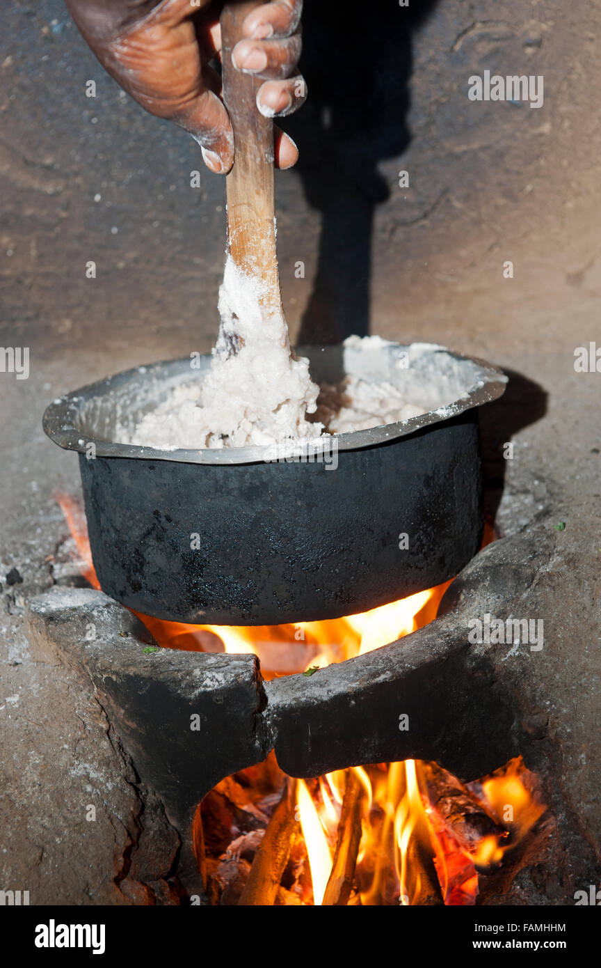 Cooking meal over an open fire in a small basic kitchen unit, Kenya ...