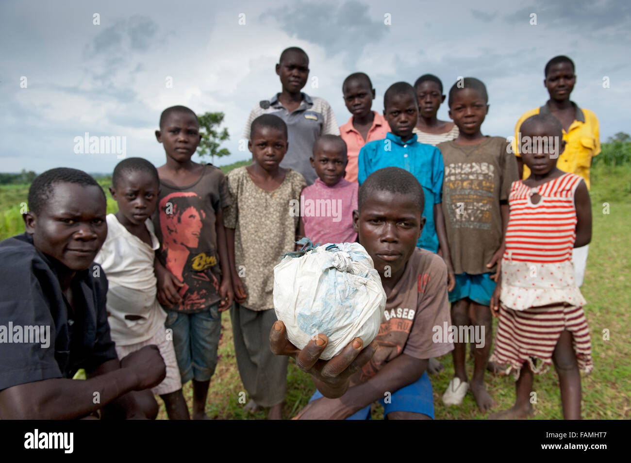 Childrens football team posing with a ball made of plastic bags. Rural ...